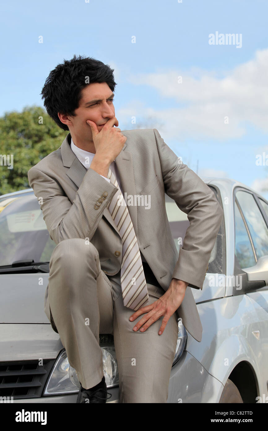 Businessman thinking by his car Stock Photo - Alamy
