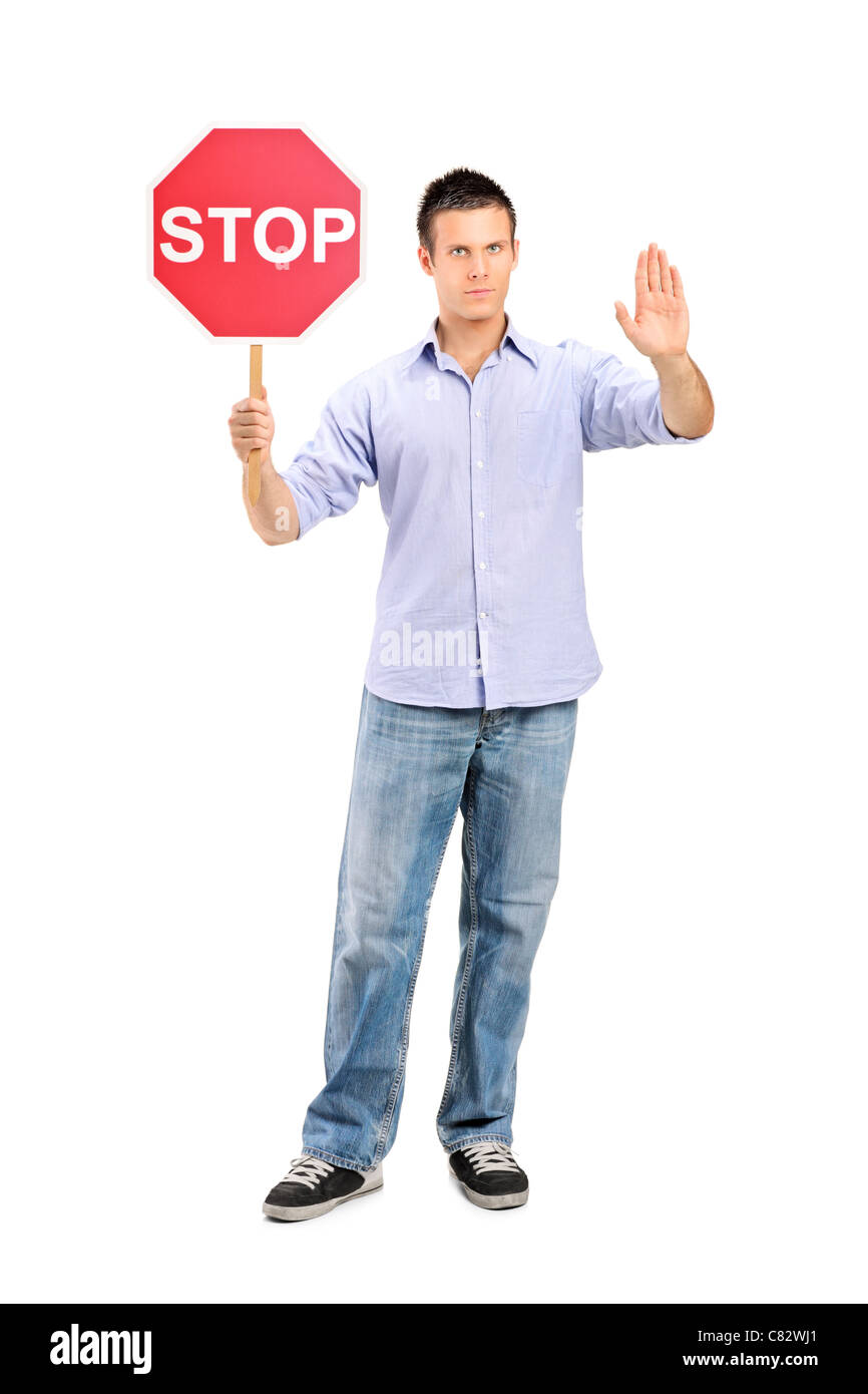 Full length portrait of a man gesturing and holding a traffic sign stop ...