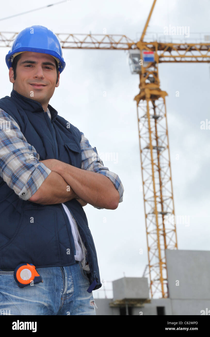 Construction worker in front of a crane Stock Photo - Alamy