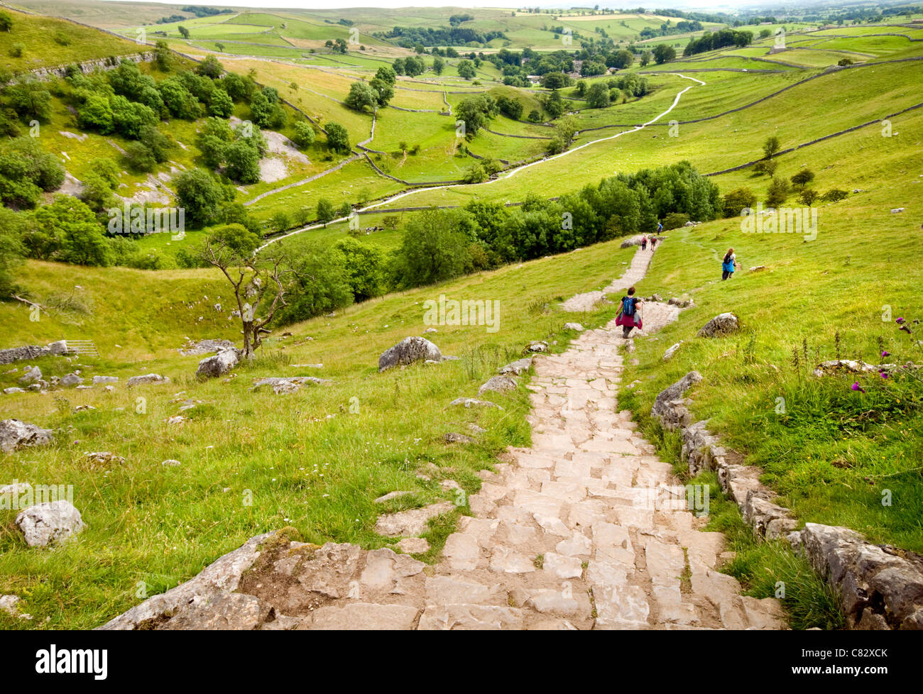 Walkers making their way down the path leading up to the limestone ...