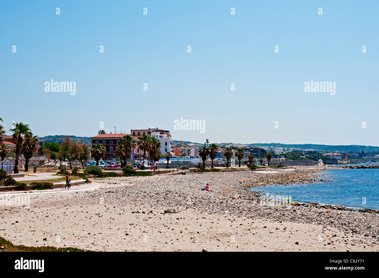 People sunbathing on the uncomfortable rocky beach with the peaceful ...