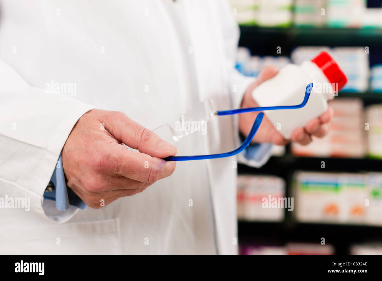 Pharmacist -only hands to be seen -standing in pharmacy with ...