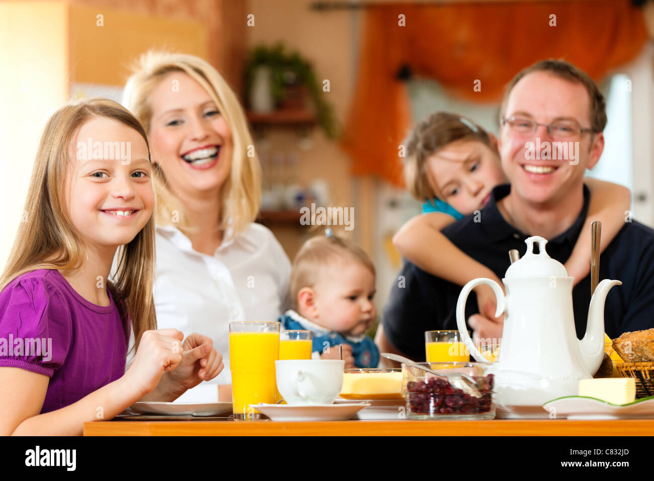 Family eating breakfast in the kitchen of their house Stock Photo - Alamy
