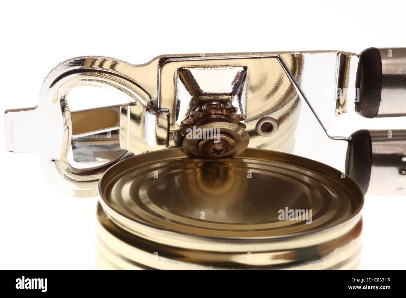 Tin opener opening a can of food isolated on white Stock Photo - Alamy