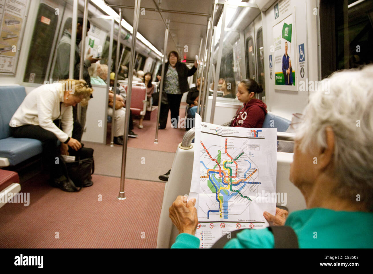 An elderly lady reading a map of the metro subway rail system ...