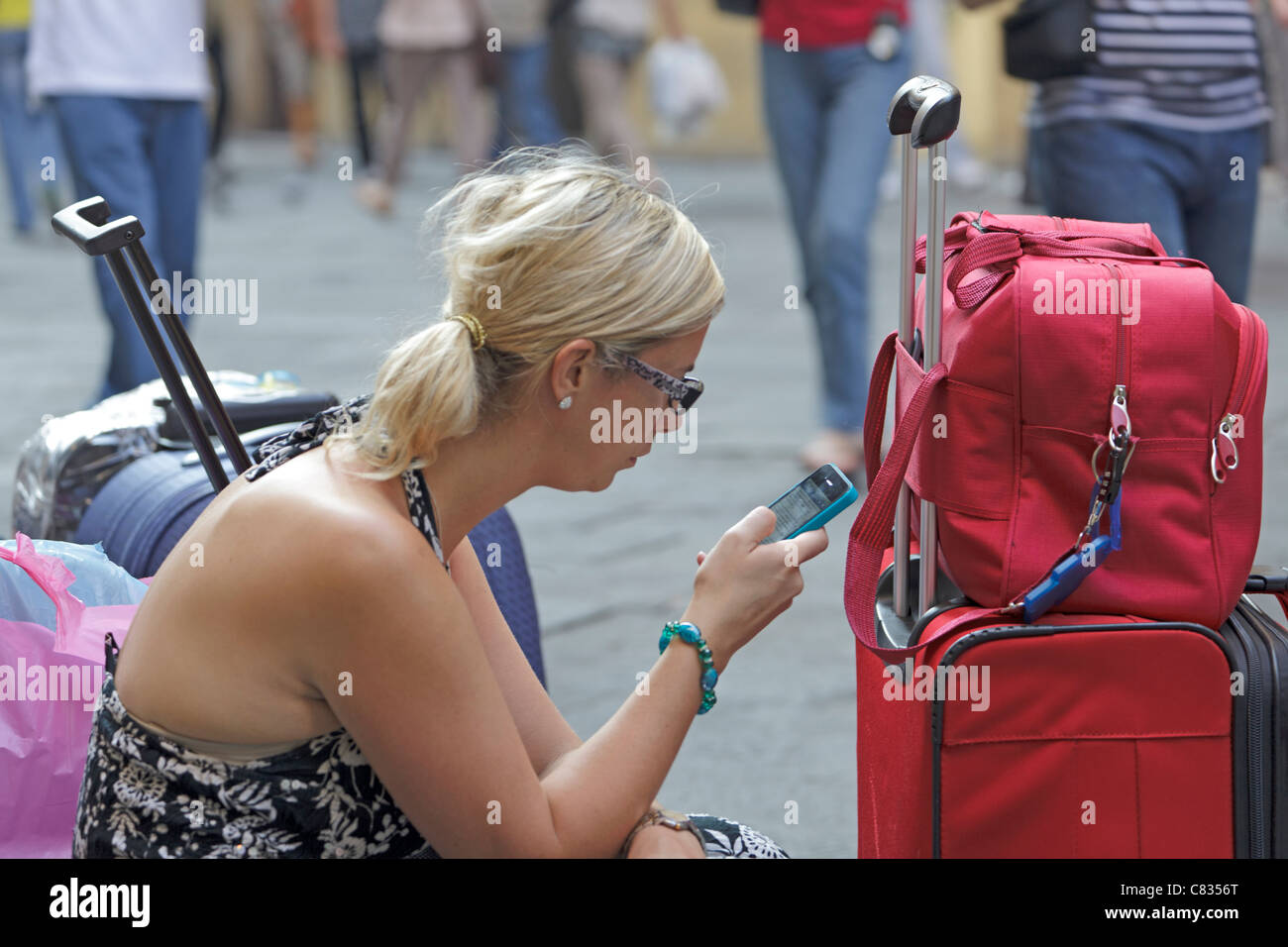 Lady traveller using mobile phone with luggage around her Stock Photo ...