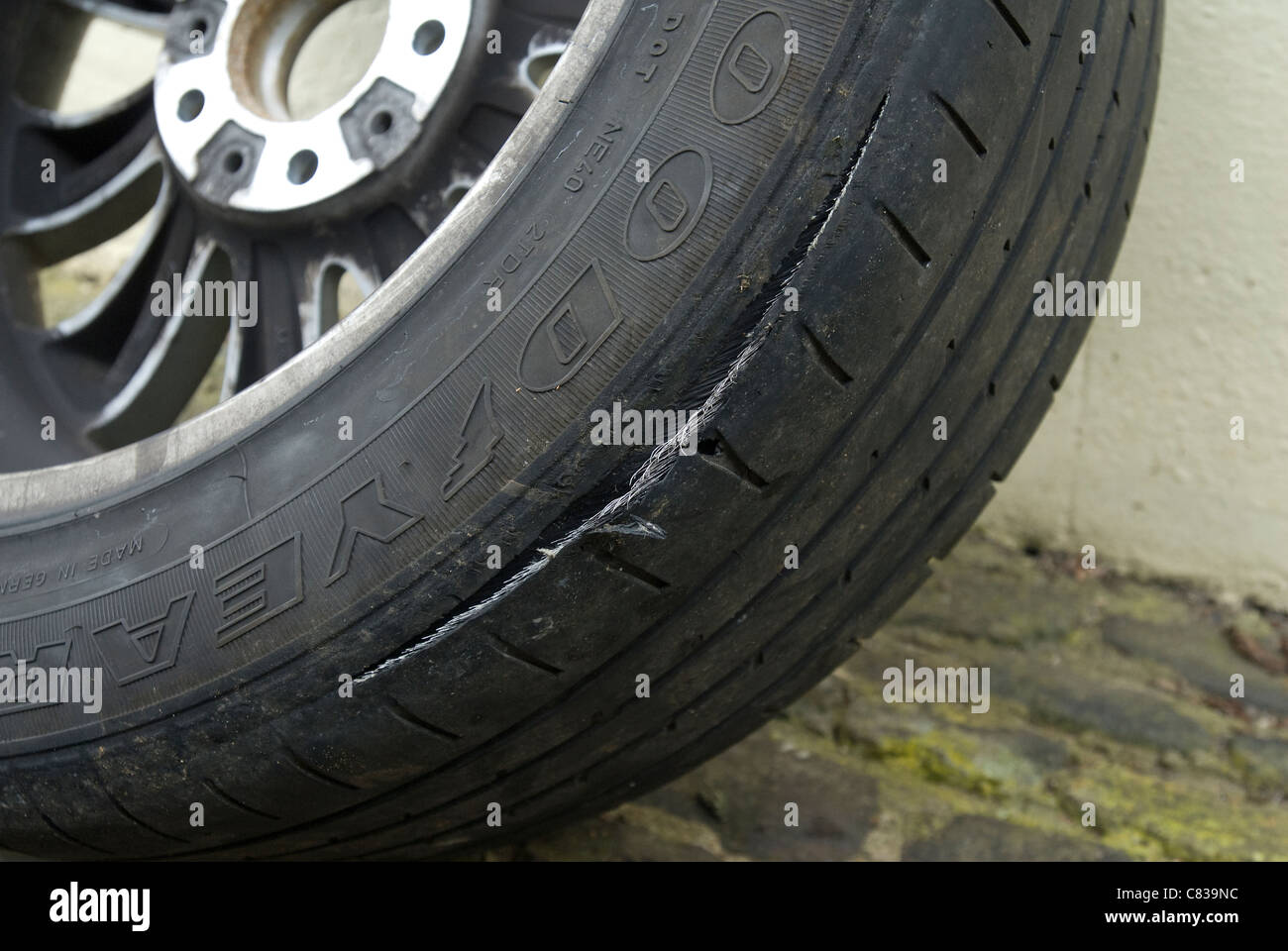 Split in run flat tyre exposing steel belting Stock Photo - Alamy