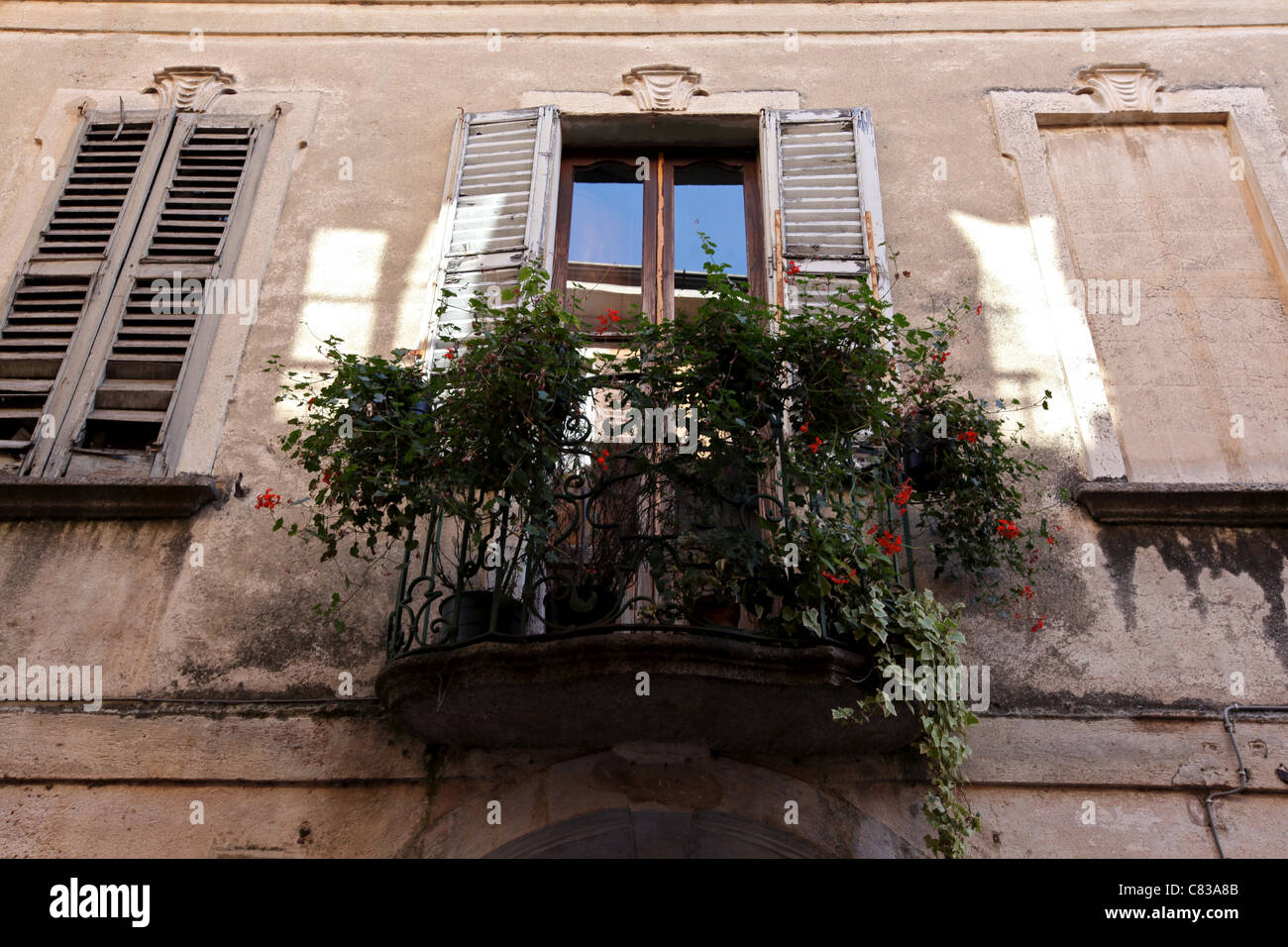 A facade of a typical Italian building with a balcony full of flowers ...