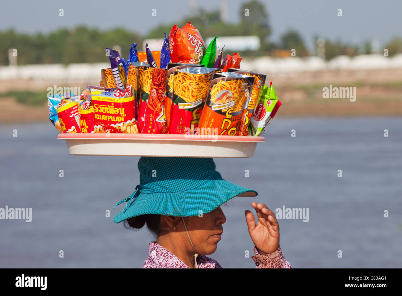 Cambodia, Phnom Penh, Street Vendor Carrying Packets of Junk Food on ...