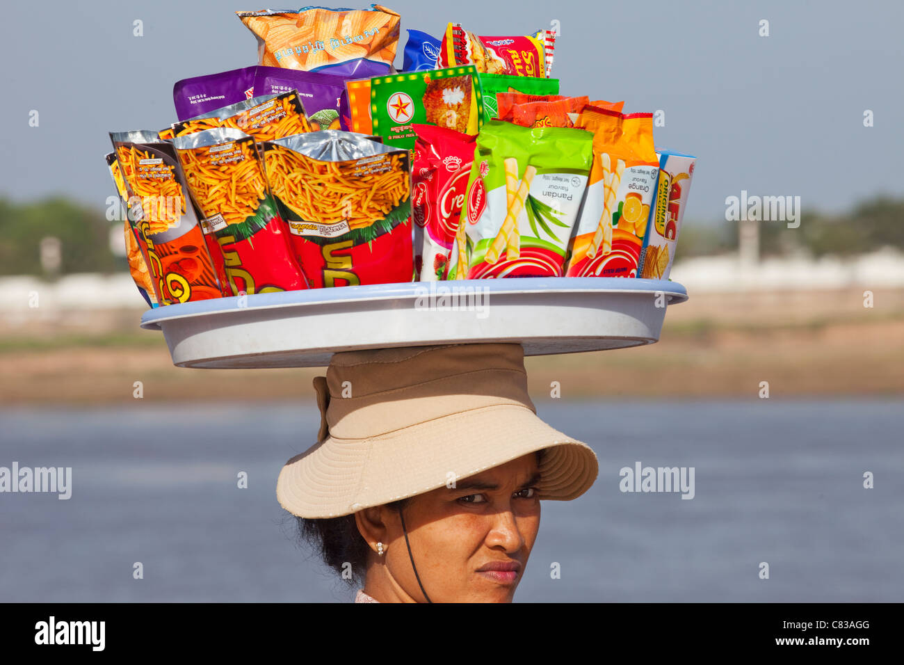 Cambodia, Phnom Penh, Street Vendor Carrying Packets of Junk Food on ...