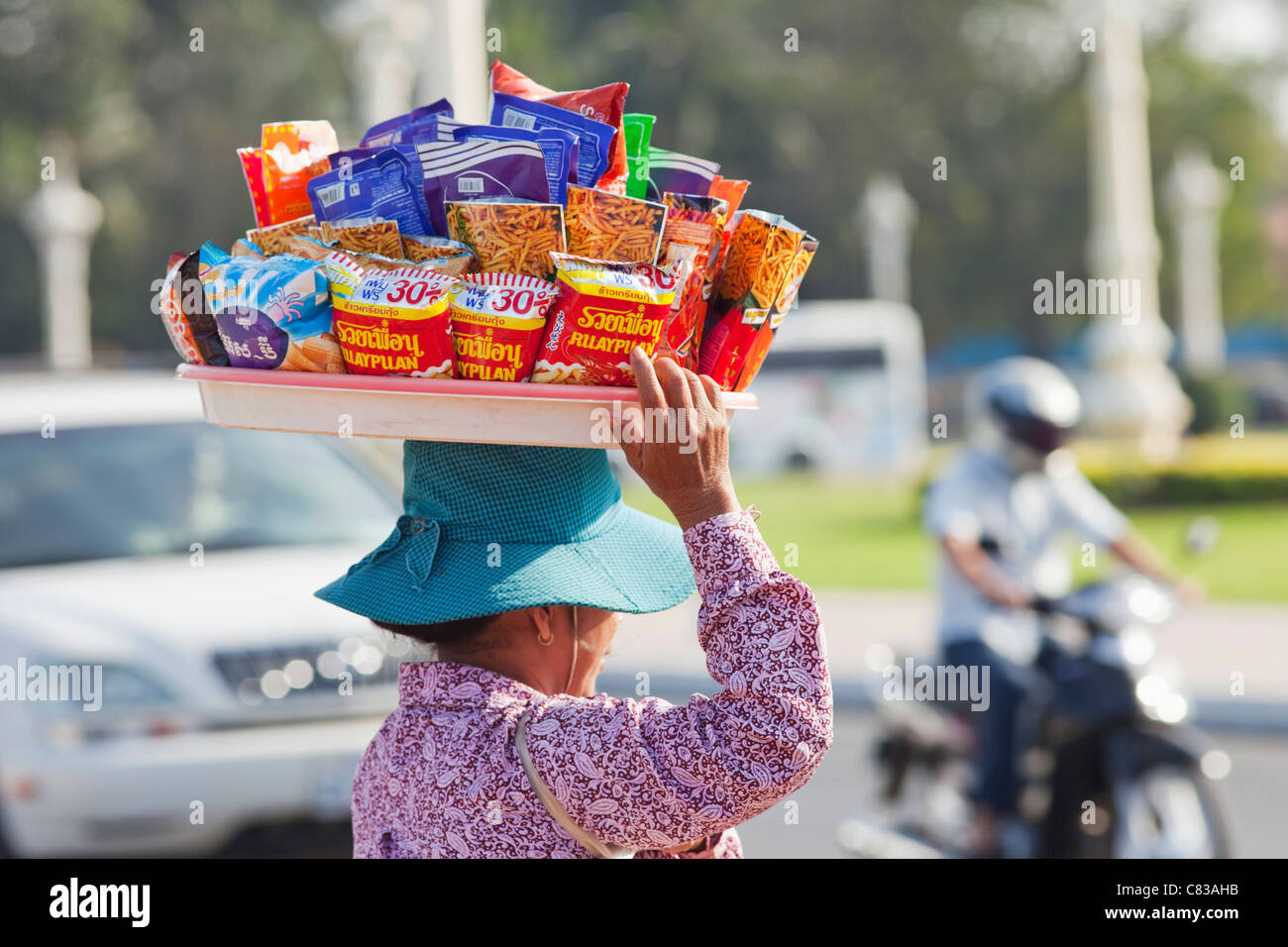 Cambodia, Phnom Penh, Street Vendor Carrying Packets of Junk Food on ...