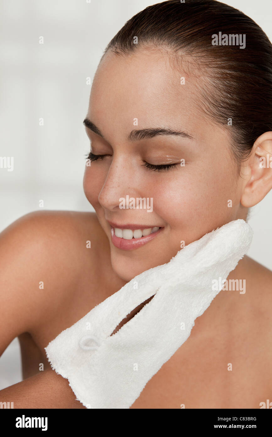 Woman scrubbing her face with cloth Stock Photo - Alamy