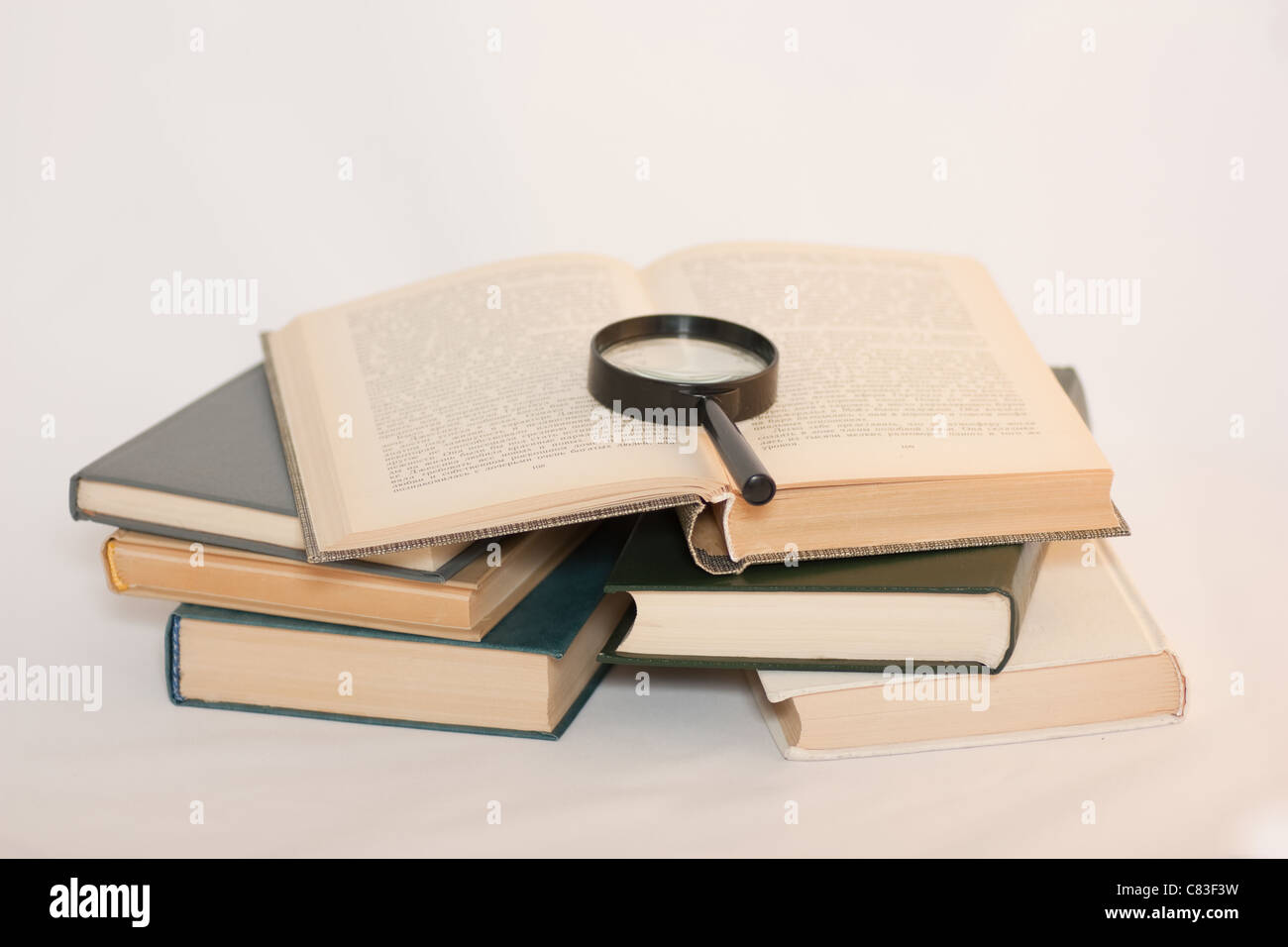 Magnifying glass on books Stock Photo - Alamy