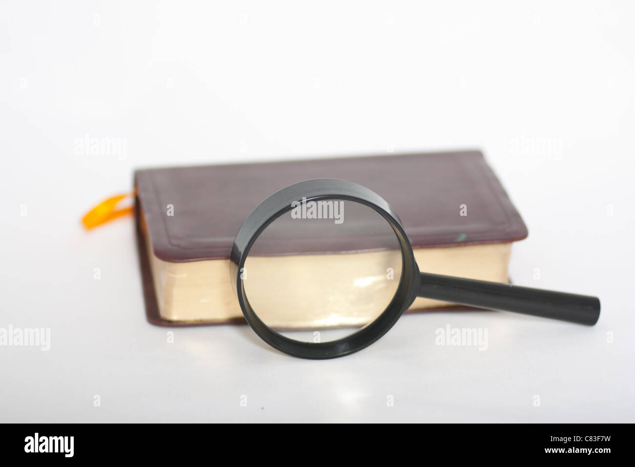 Magnifying glass on book Stock Photo - Alamy