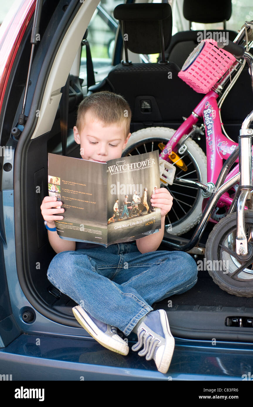young boy reading the watchtower magazine in back of family car,jehovas ...
