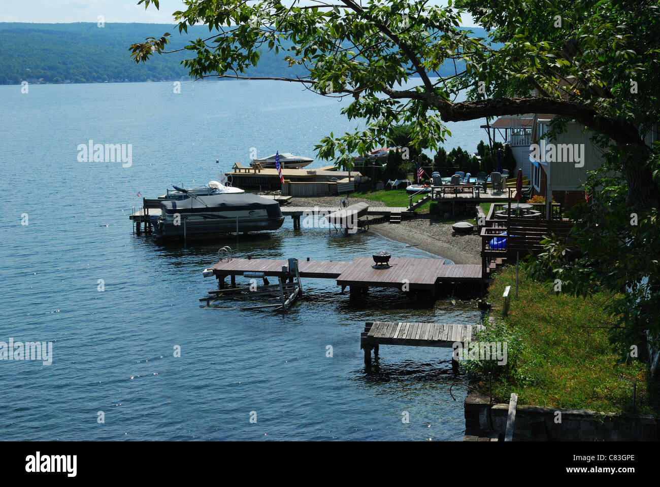 Boats and docks at cottages. Calm blue water Stock Photo - Alamy