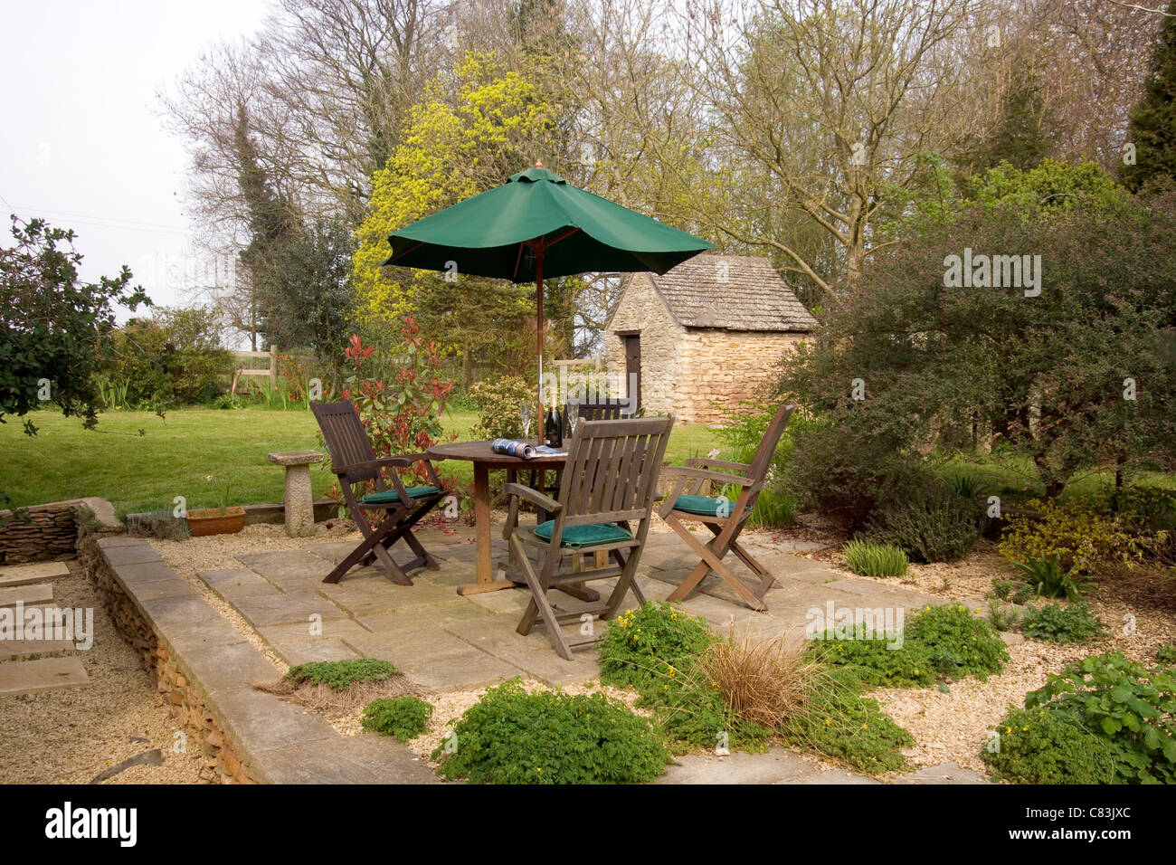 UK gardens. Patio table and chairs in a spring garden Stock Photo - Alamy