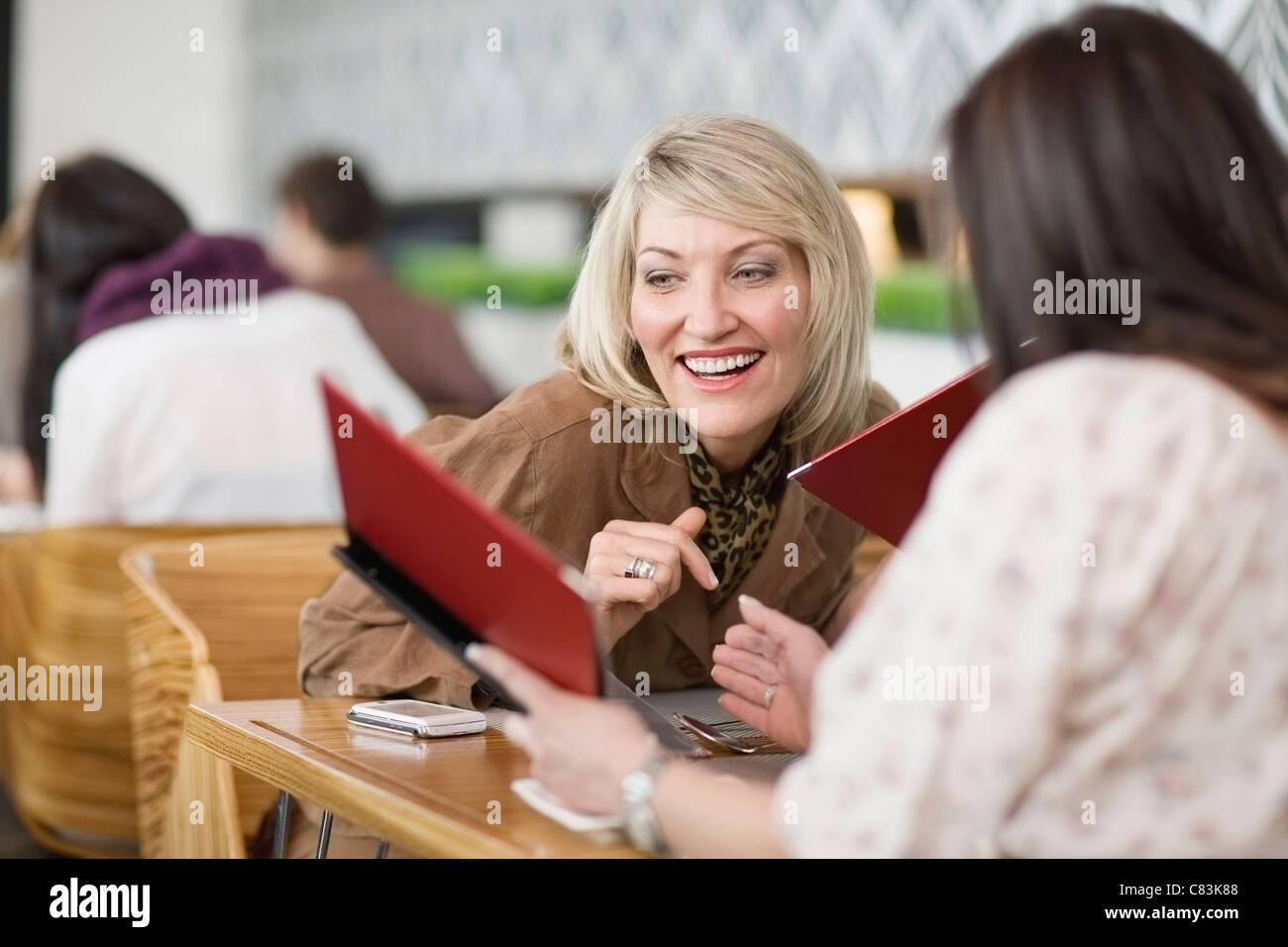 Businesswomen reading menus at lunch Stock Photo - Alamy