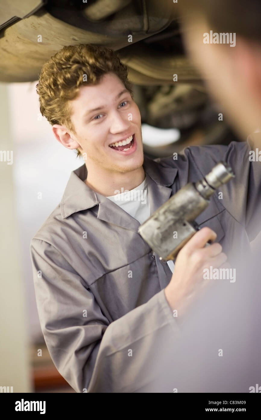 Mechanic working on car in garage Stock Photo - Alamy