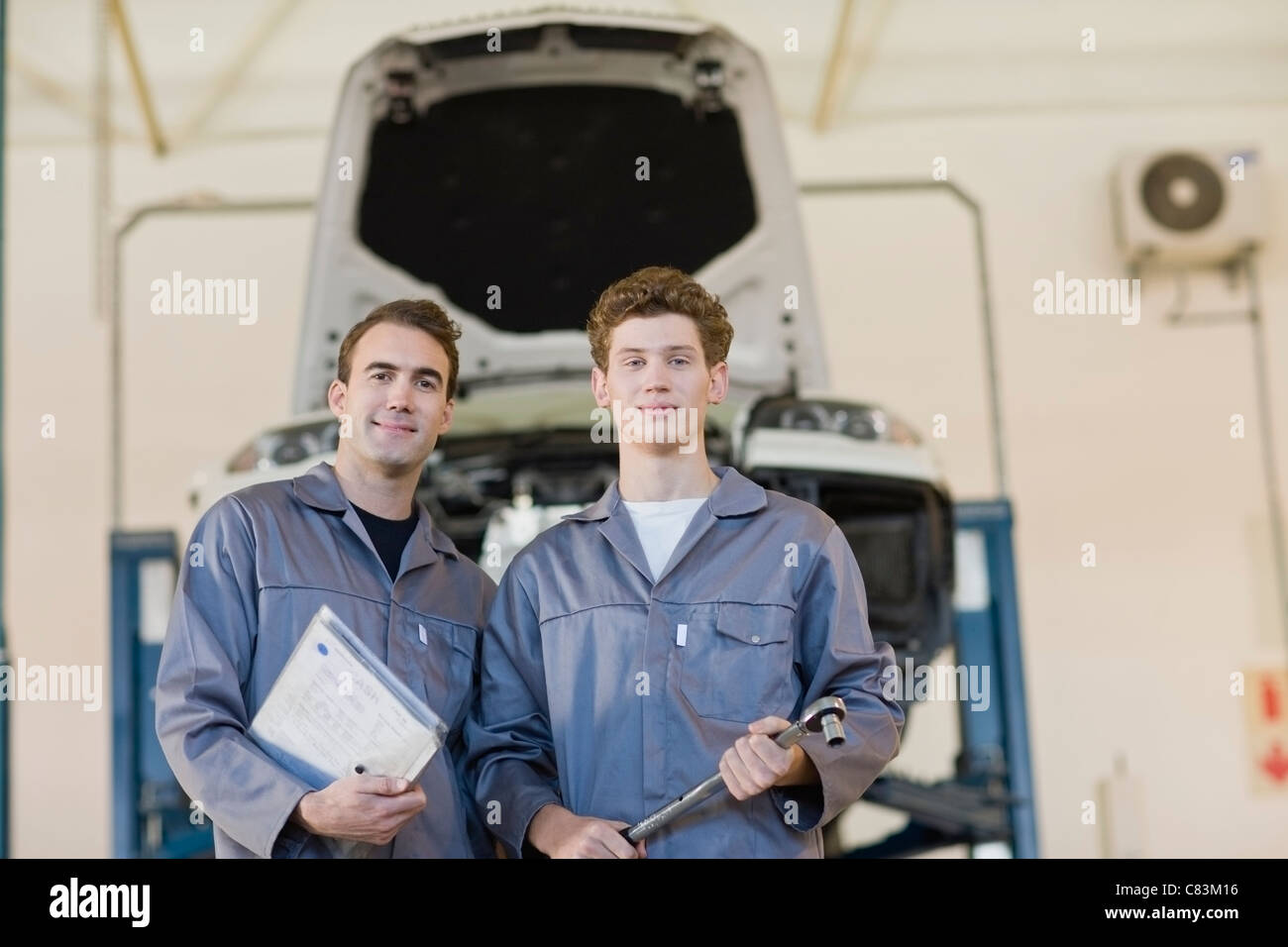 Mechanics standing together in garage Stock Photo - Alamy