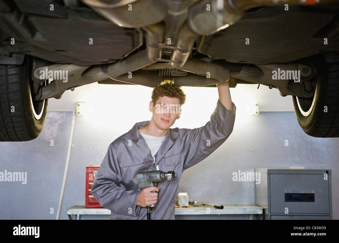 Mechanic working on car in garage Stock Photo - Alamy