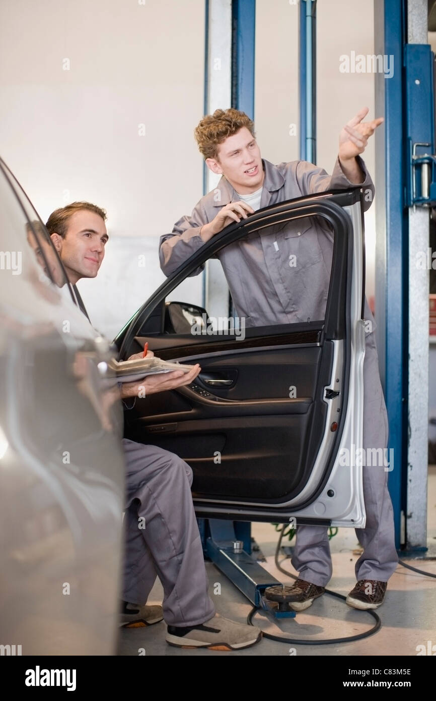 Mechanics working in garage Stock Photo - Alamy