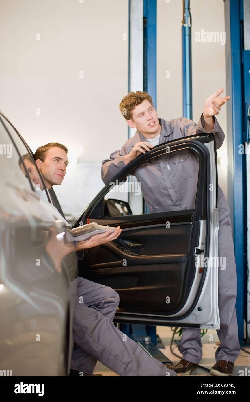 Mechanics working in garage Stock Photo - Alamy