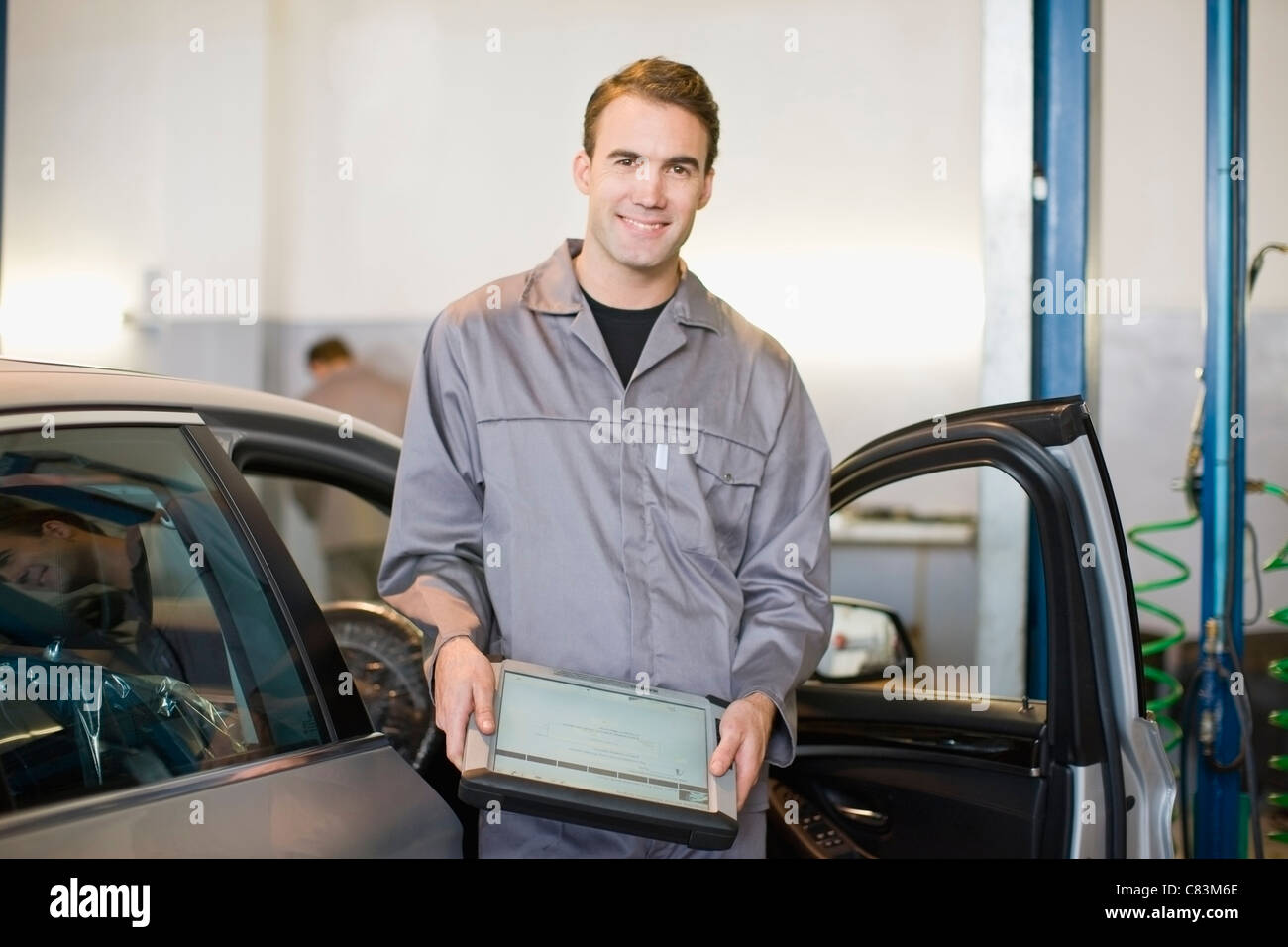 Mechanic with tablet computer in garage Stock Photo - Alamy