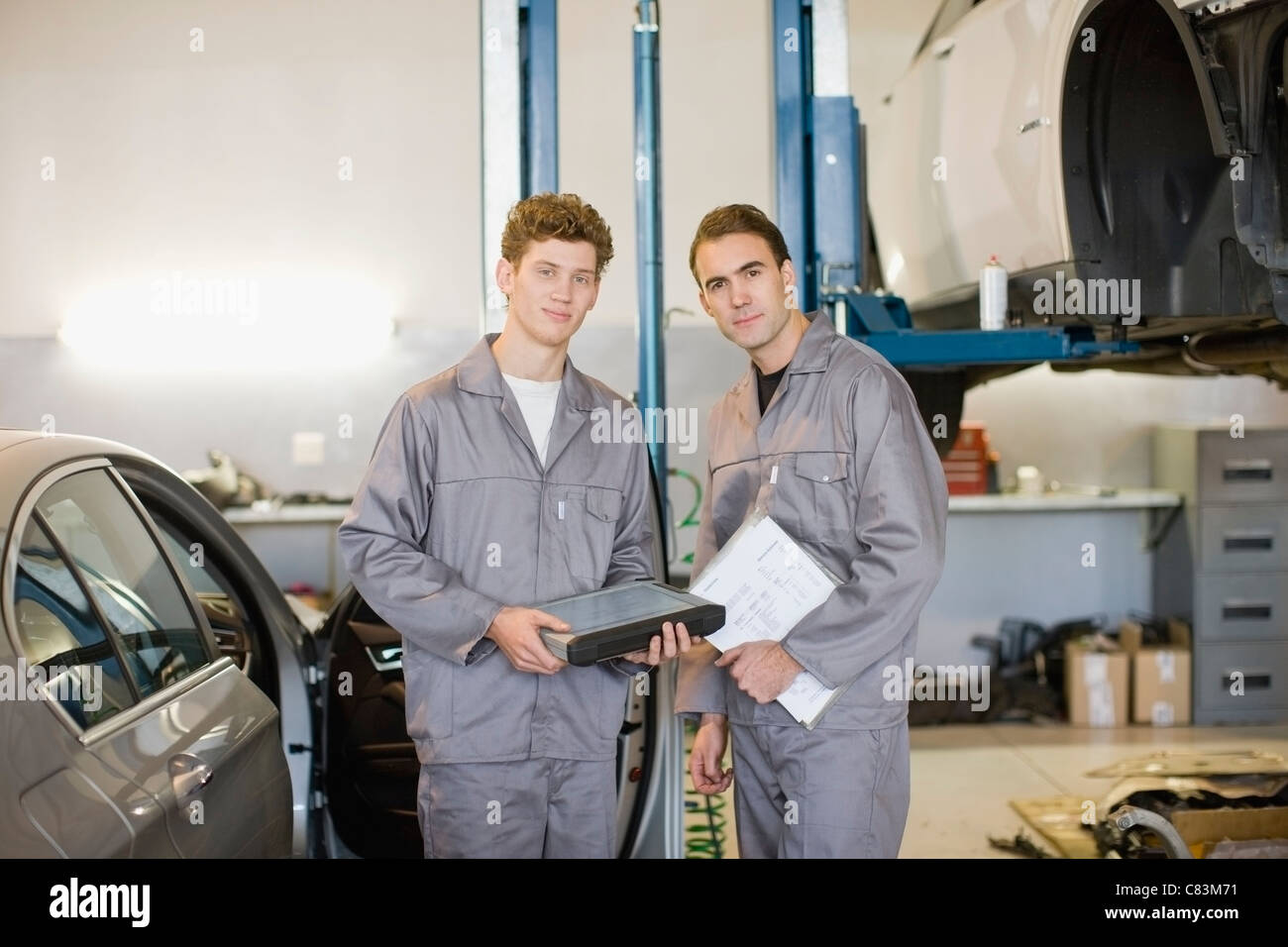 Mechanics working in garage Stock Photo - Alamy