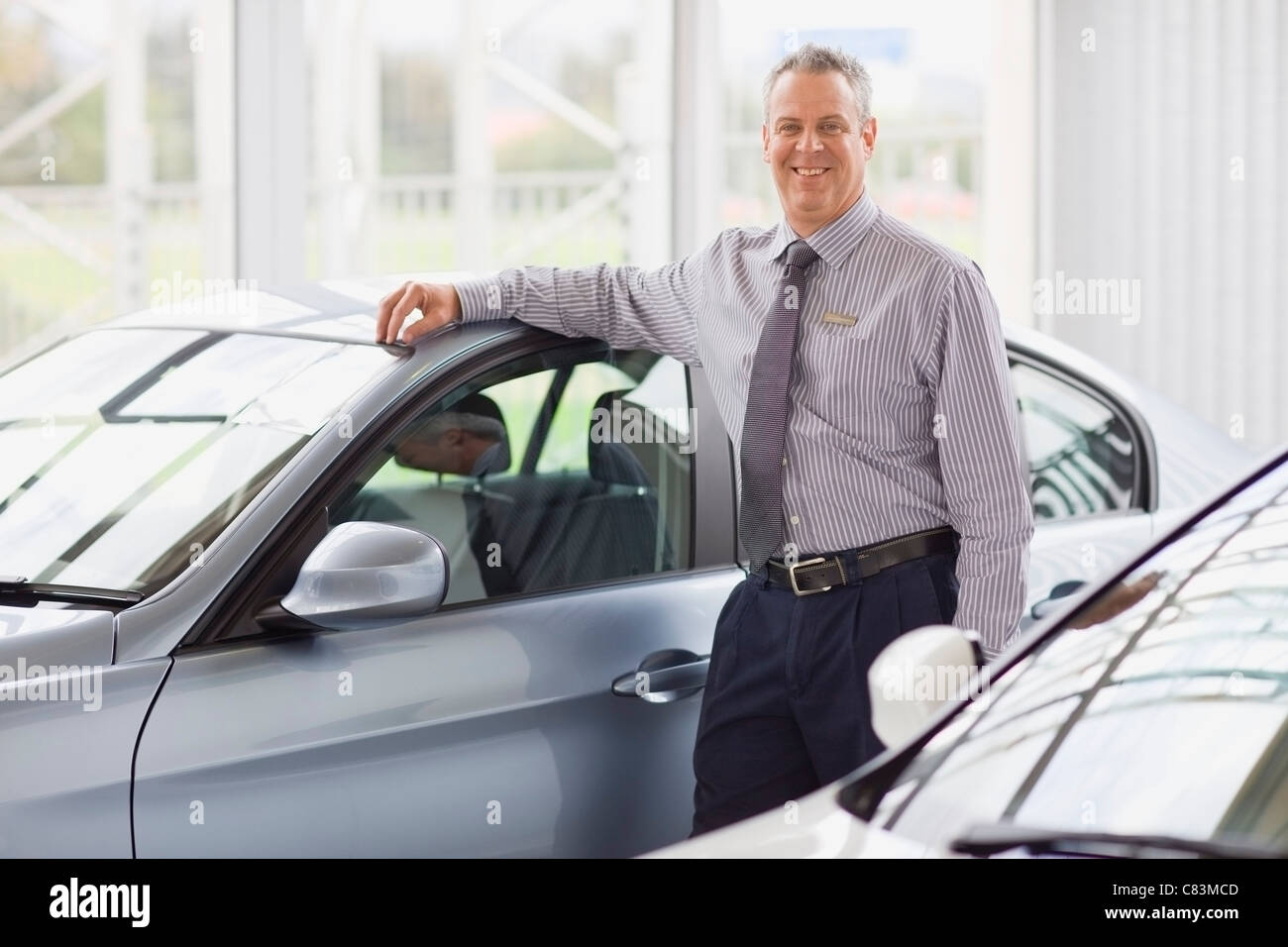 Salesman posing car showroom hi-res stock photography and images - Alamy