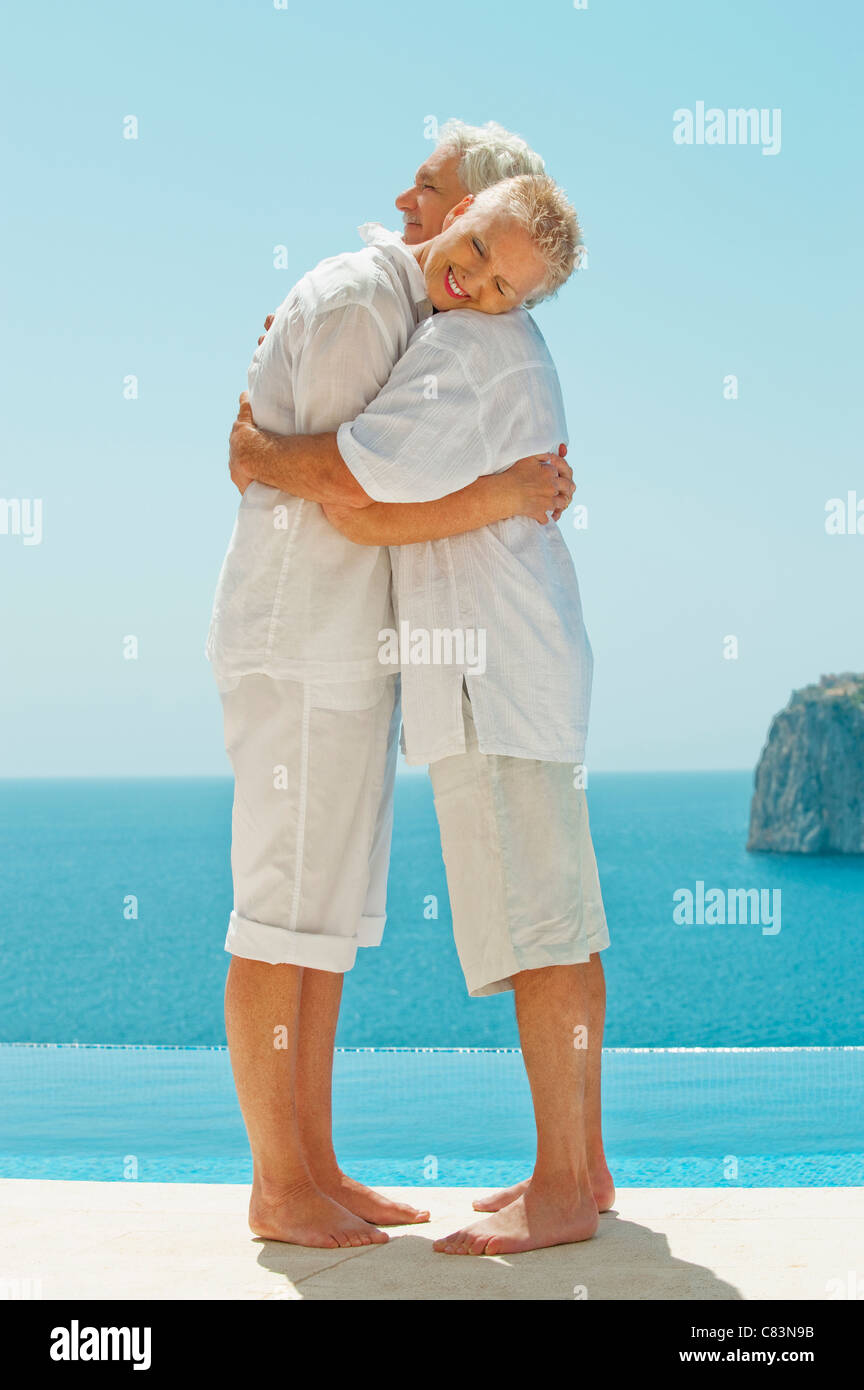 Couple hugging and overlooking sea Stock Photo - Alamy
