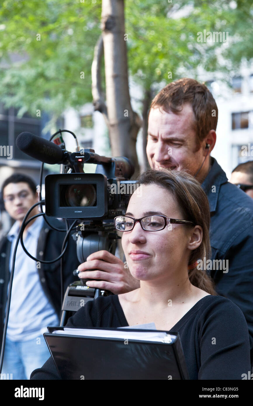young woman reporter with videographer conducts an interview in ...