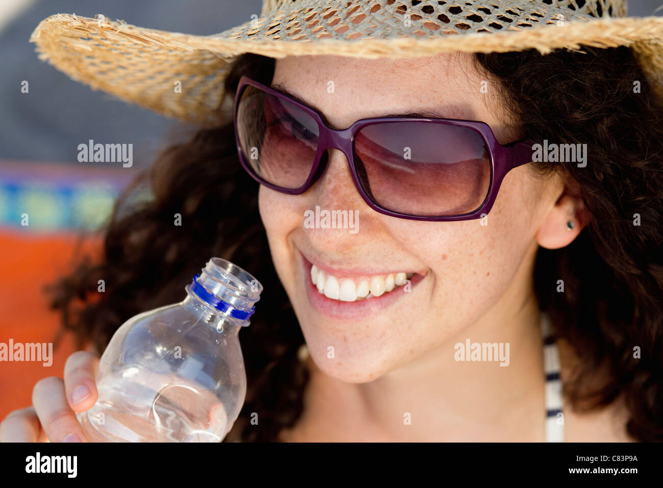 Smiling woman drinking water Stock Photo - Alamy