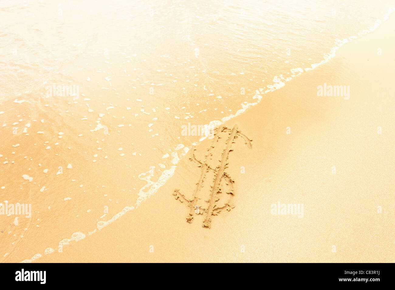 Dollar sign in sand washed away by waves Stock Photo - Alamy