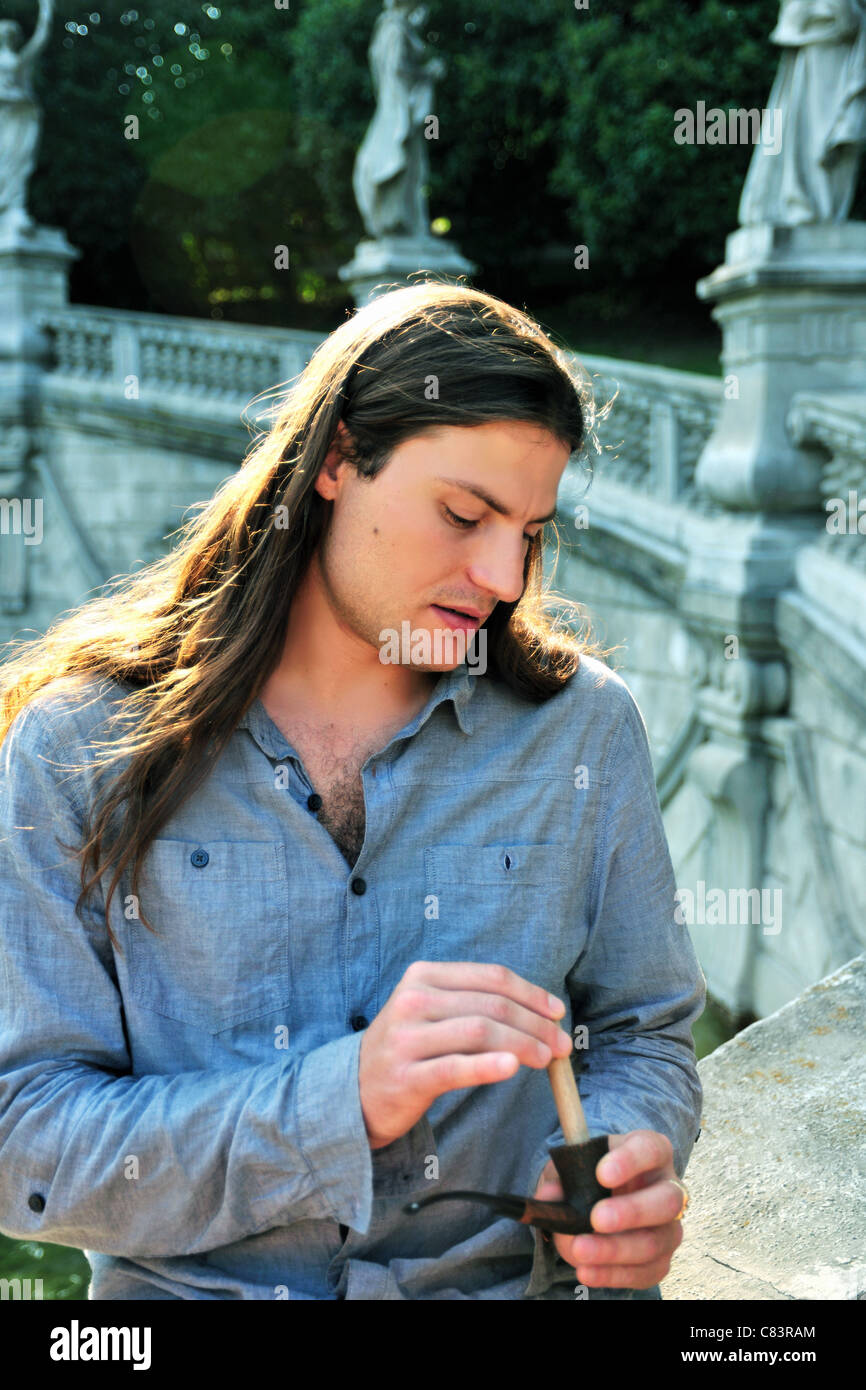 Man packing pipe outdoors Stock Photo - Alamy