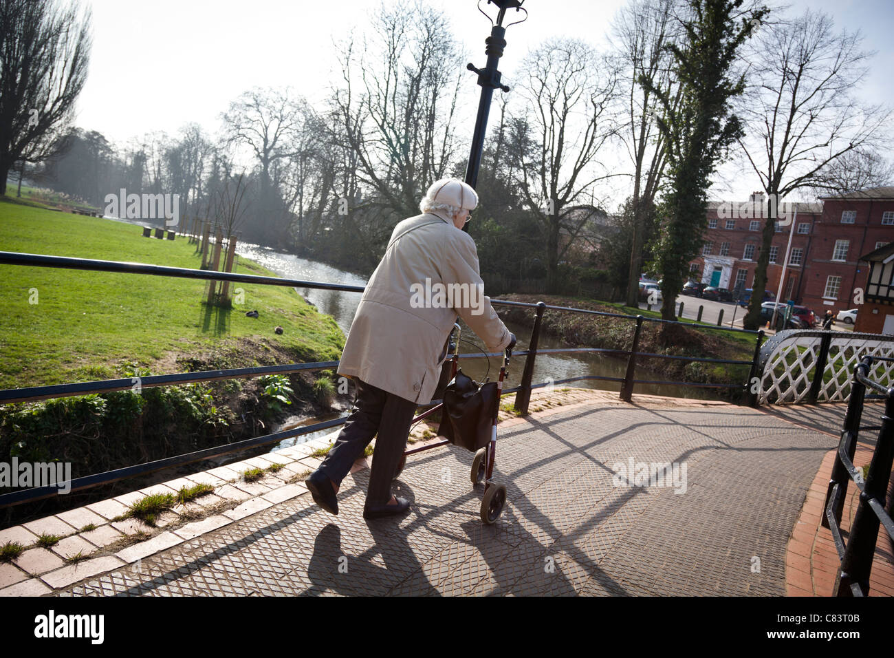 Elderly woman using a 3 wheeled walking frame Stock Photo - Alamy
