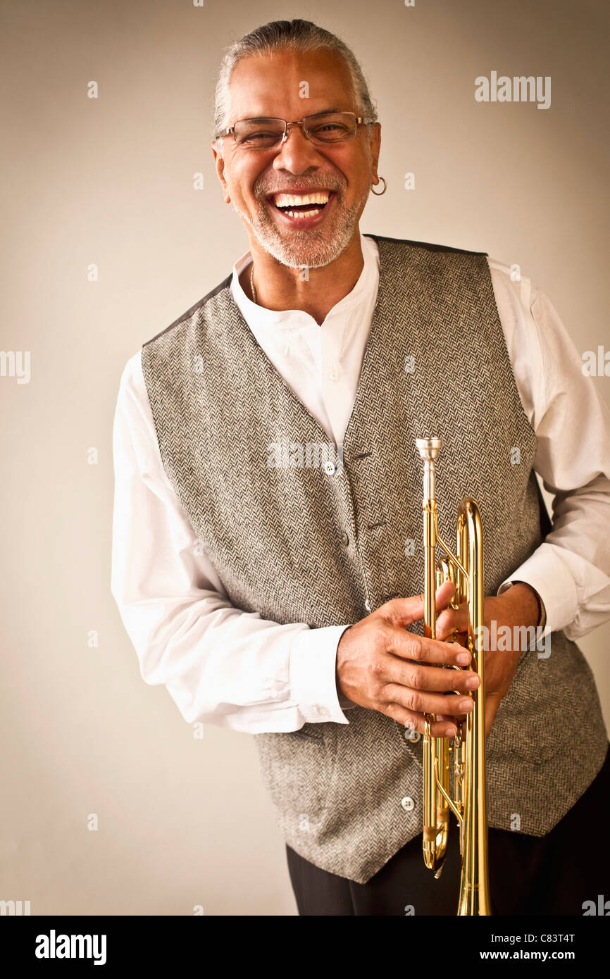 Laughing musician holding trumpet Stock Photo - Alamy