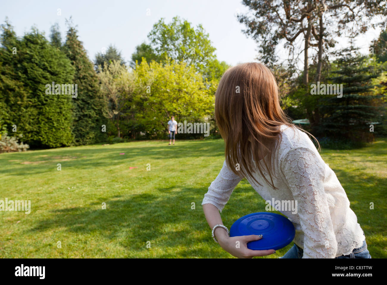 Teenage girl prepares to throw a frisbee in the garden Stock Photo - Alamy