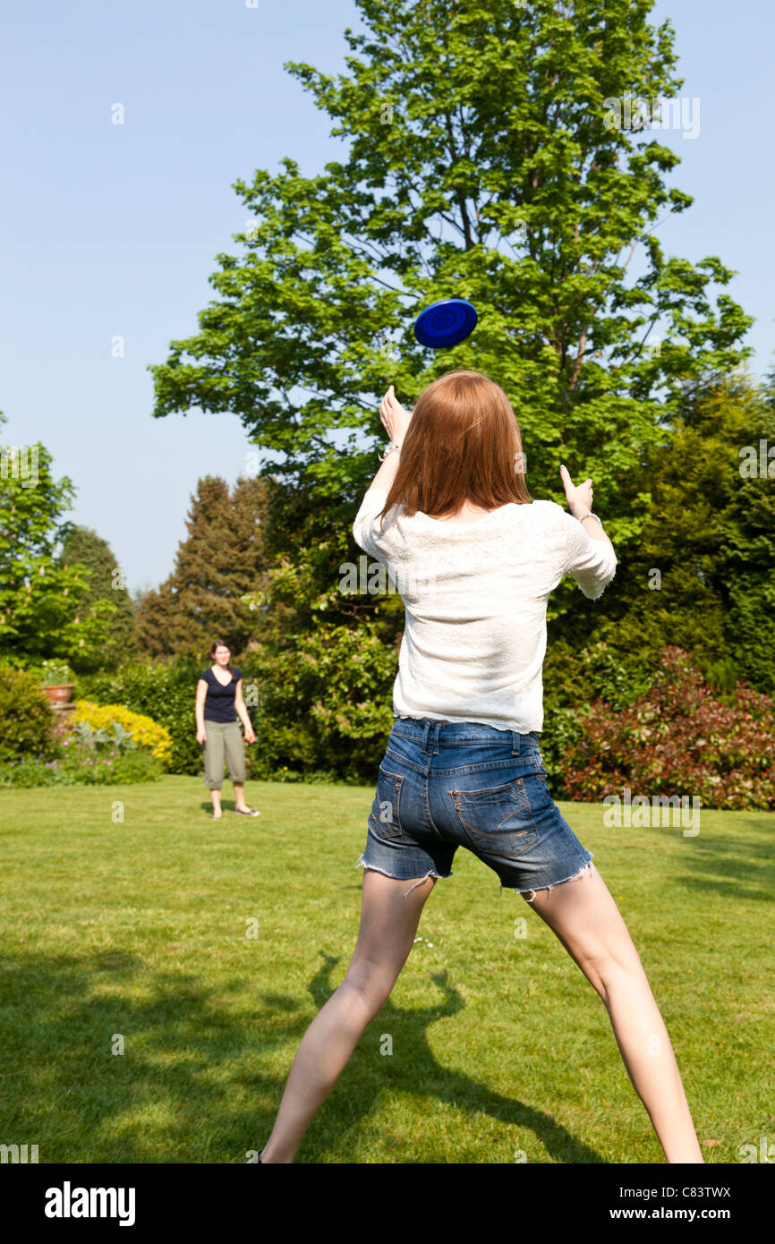 Teenage girl prepares to catch a frisbee in the garden Stock Photo - Alamy