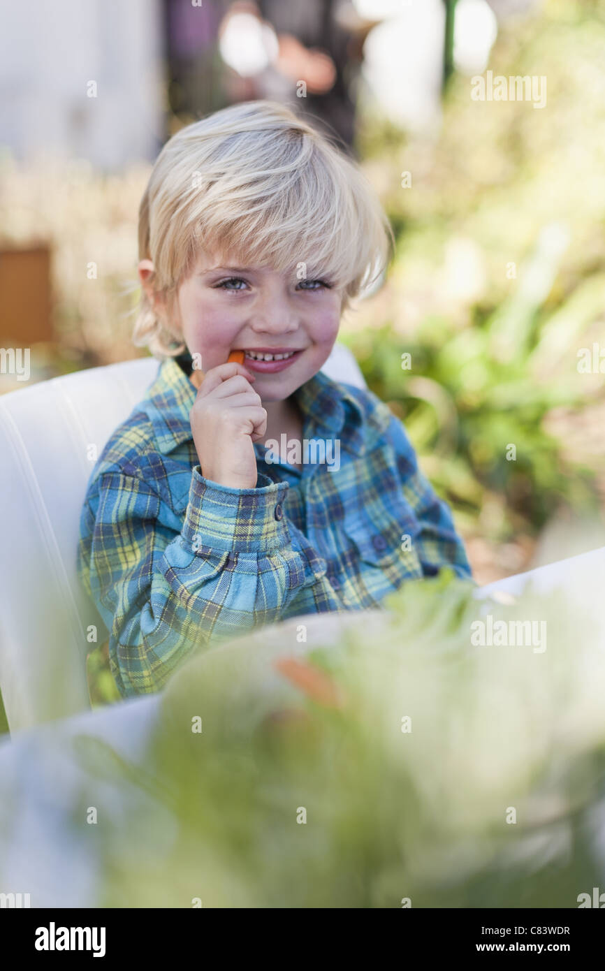 Boy eating at table outdoors Stock Photo - Alamy