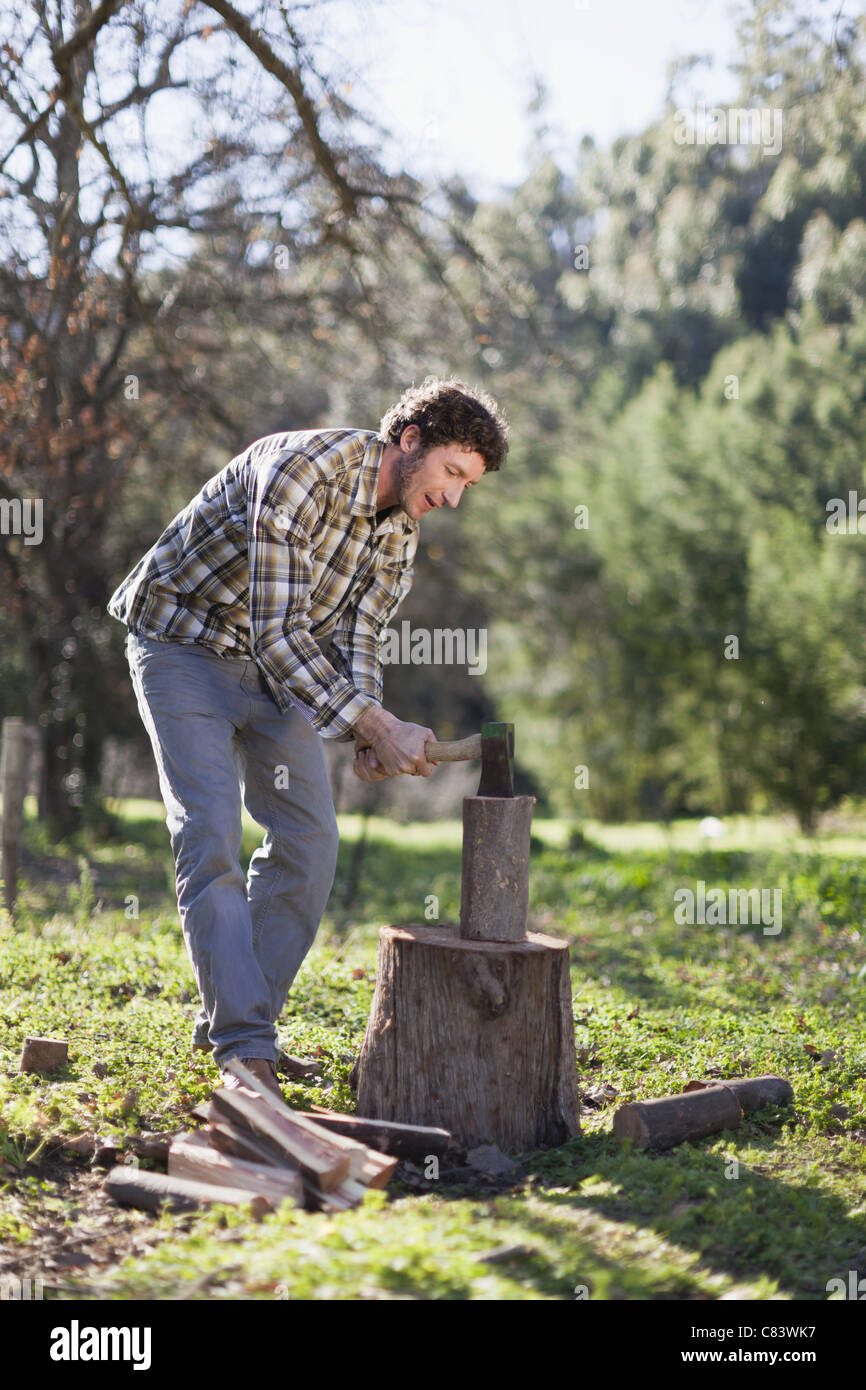 Man chopping wood outdoors Stock Photo - Alamy