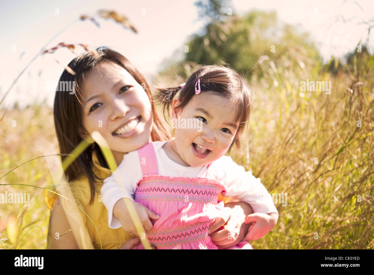 Chinese mother hugging daughter Stock Photo - Alamy