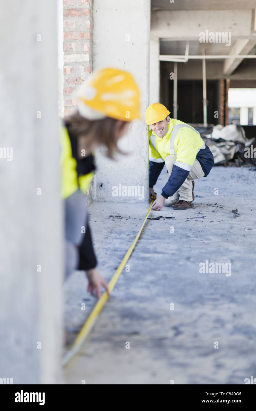 Worker measuring space on site Stock Photo - Alamy
