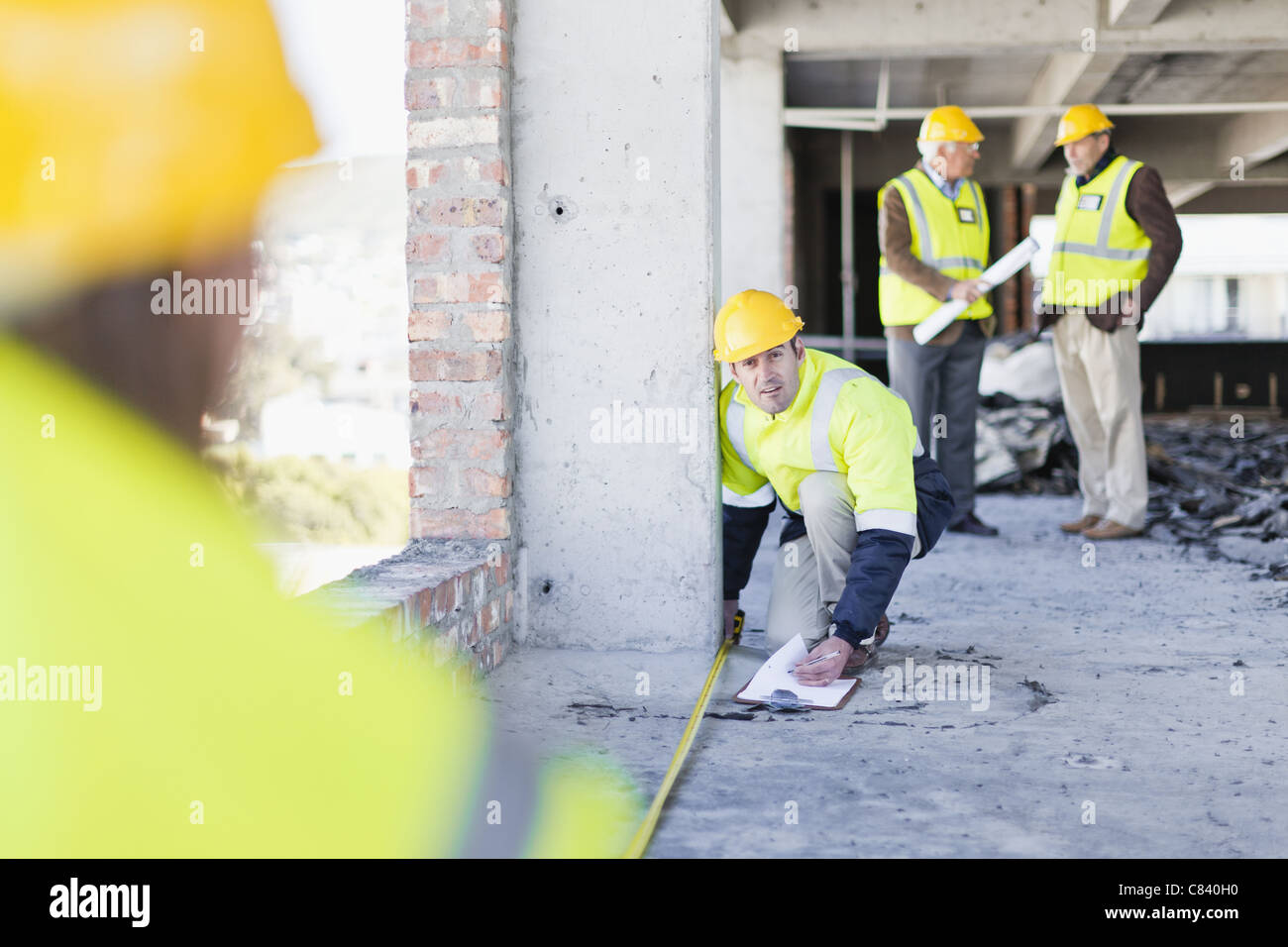 Worker measuring space on site Stock Photo - Alamy