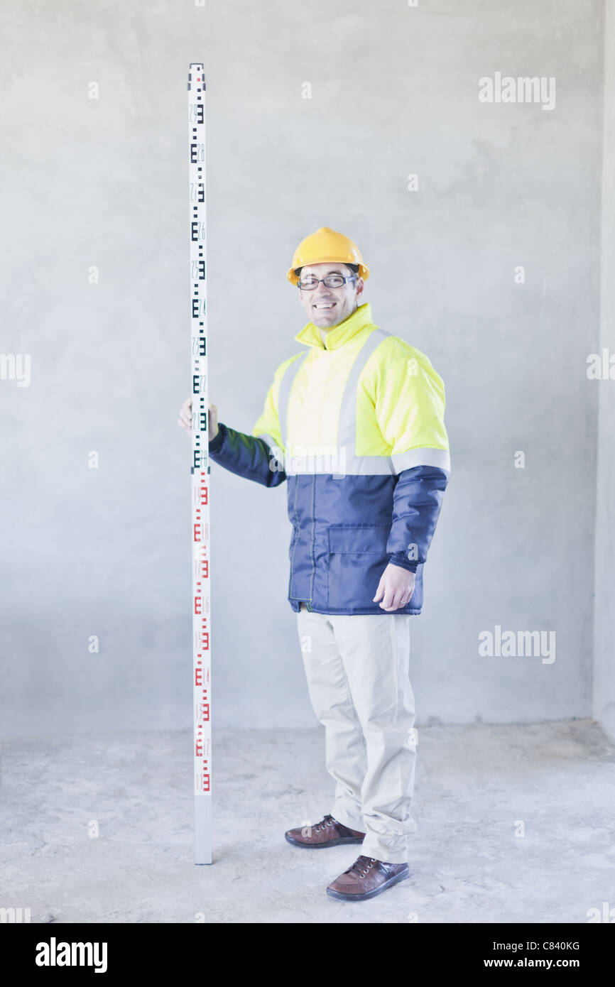 Worker measuring space on site Stock Photo - Alamy
