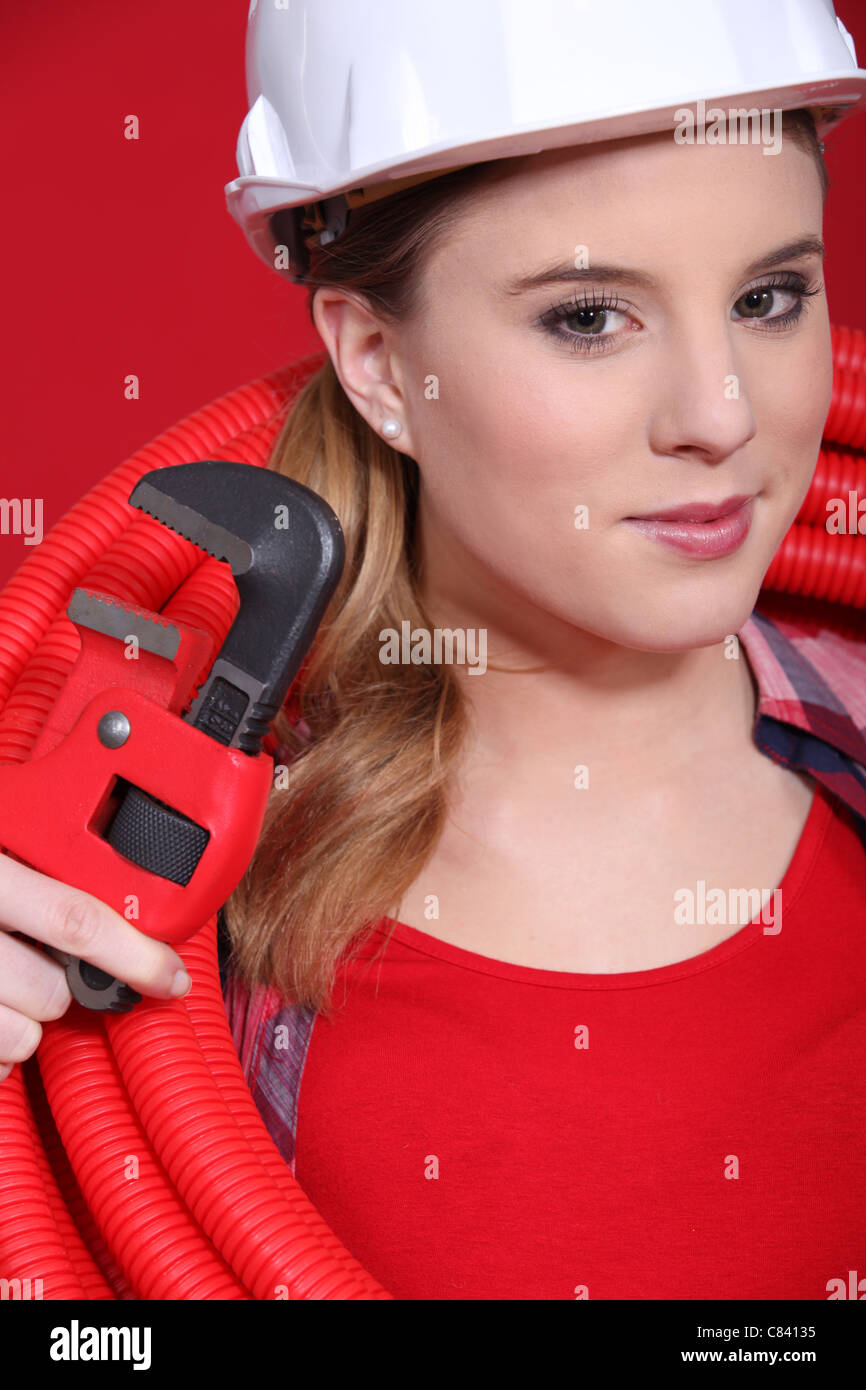 Female plumber in red with a red pipe and wrench Stock Photo - Alamy