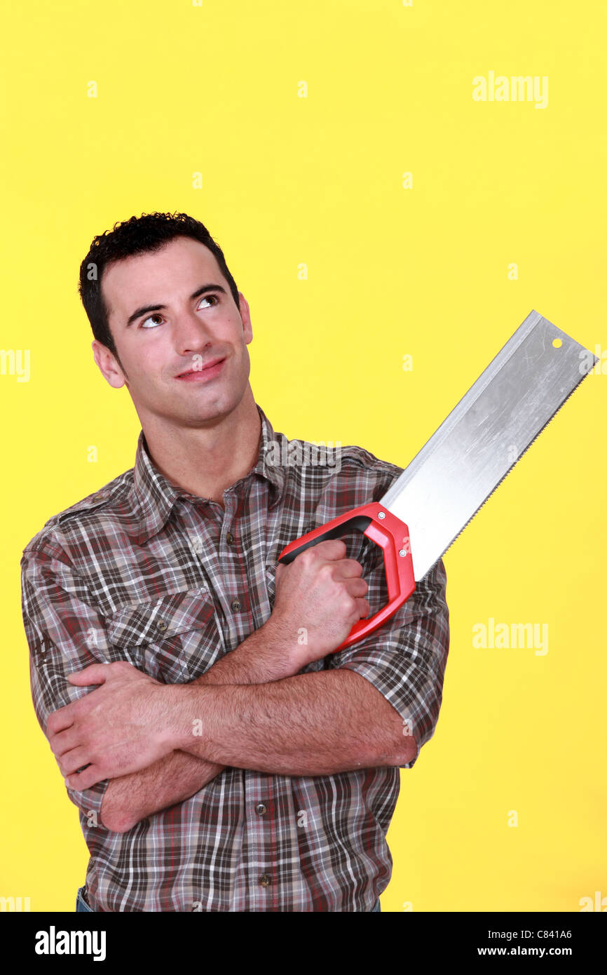 Man holding hand saw Stock Photo - Alamy