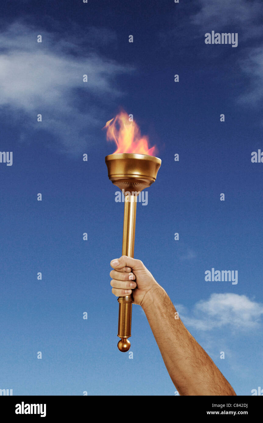 Hand holding flaming baton Stock Photo - Alamy