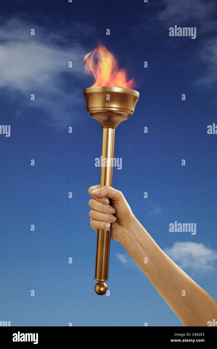 Hand holding flaming baton Stock Photo - Alamy