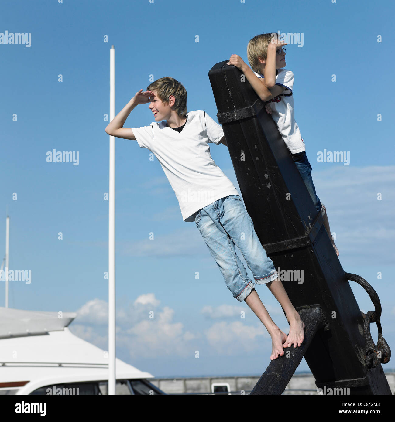 Boys climbing on pier Stock Photo - Alamy